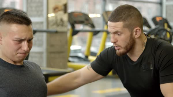 Young man shouted at by instructor while working out in gym - Stock ...