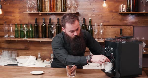 Bearded hipster barista in vintage coffee shop preparing coffee on a ...