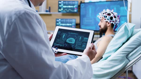 Doctor holding tablet with brain analysis in modern facility for health ...