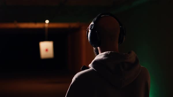 Person wearing protecting gear loading magazine in pistol during ...