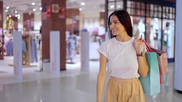 Positive beautiful female happily jumping in mall, getting out of ...