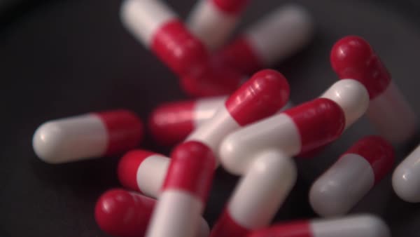 Red drug pills bouncing on speaker in slow motion filmed with high ...
