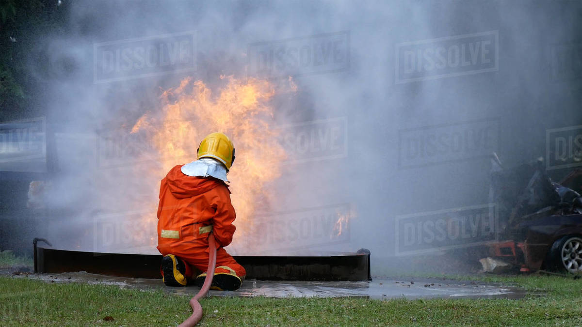 Firefighter fighting with flame using fire hose chemical water foam ...
