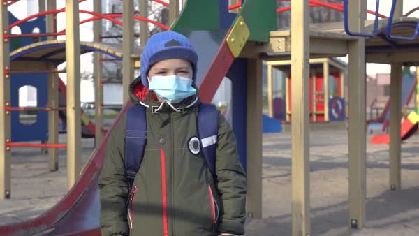 Caucasian schoolboy in face mask standing alone on children's ...