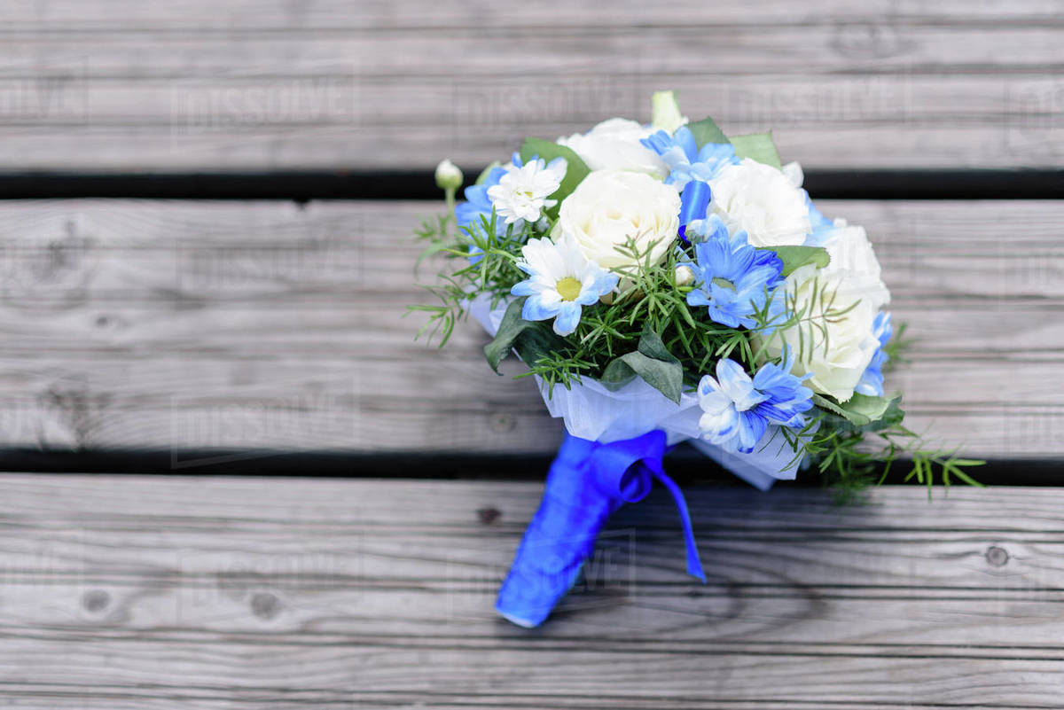 Bukey bride with blue flowers lying on a wooden pier - Stock Photo ...