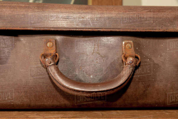 A rusty carry handle on an old brown leather suitcase - Stock Photo ...