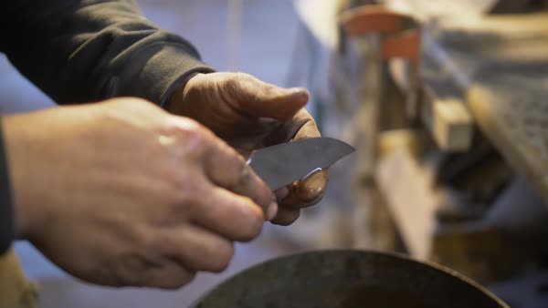 Close-up shot of a young man's hands working with piece of metal in ...