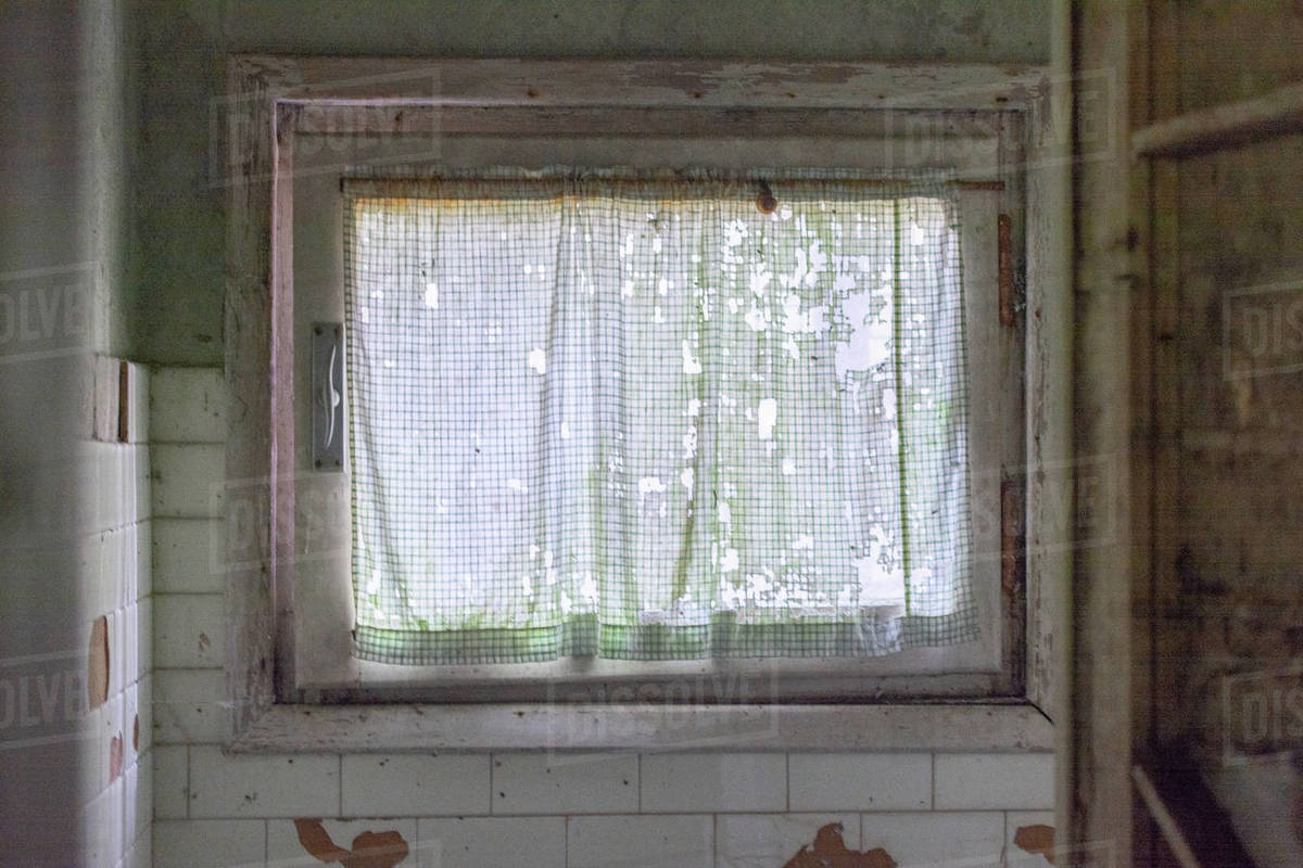 Old window in the old abandoned and creepy house with curtain and ...