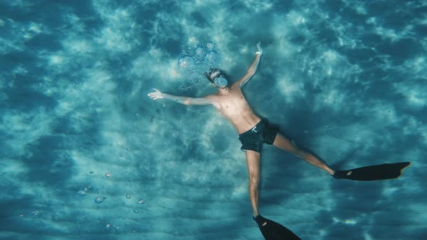 Young boy does freediving apnea underwater circular bubbles in the ...