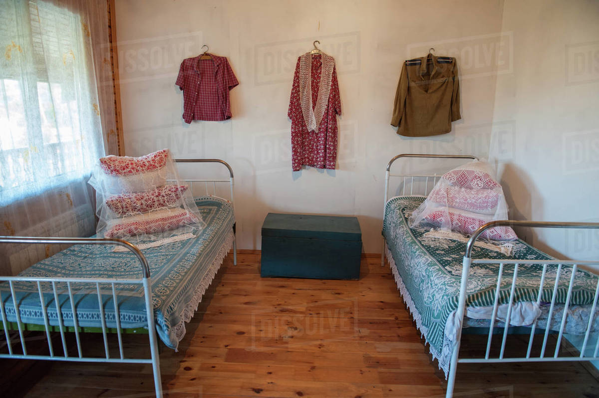 Old Slavic interior, bedroom with two beds, male and female clothes ...