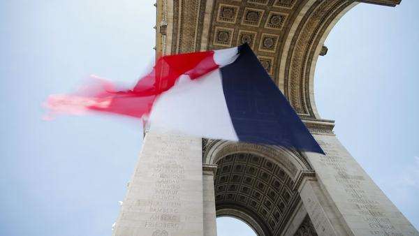 French flag flying under the Arc de Triomphe in Paris, France ...