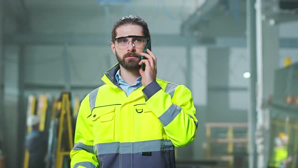 Caucasian male young engineer in goggles and yellow uniform standing in ...