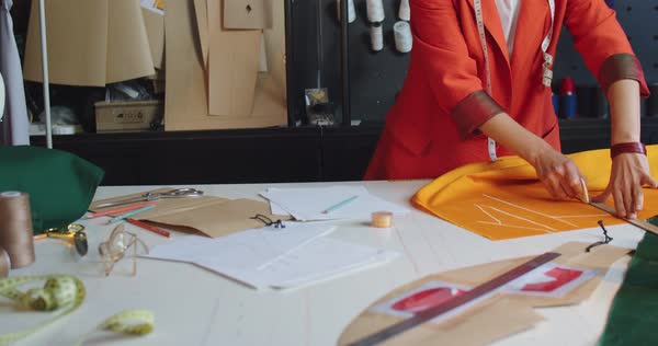 Close up of female hands taking measurements using sewing items, ruler ...