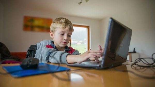 Young child typing on laptop personal computer. Very young kid doing ...