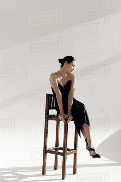 Young woman poses and relaxes with closed eyes in studio sitting on ...