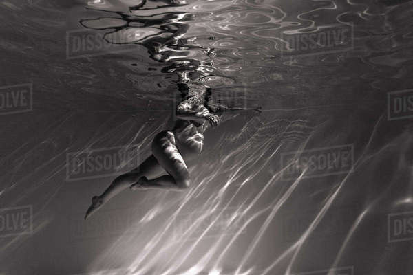 Underwater shoot of beautiful pregnant woman dancing in water in ...