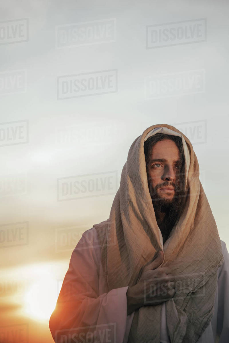 Prophet in his traditional white robe against sunset sky background ...