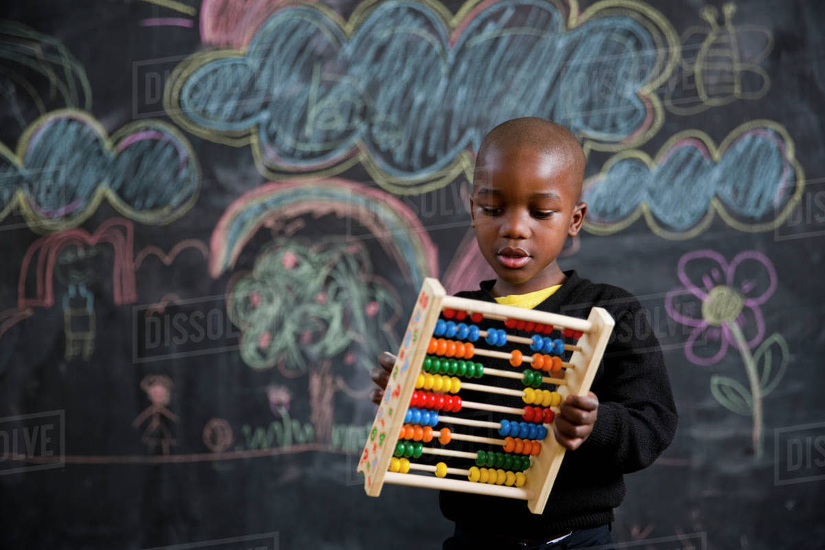 A boy counting on abacus - Stock Photo - Dissolve