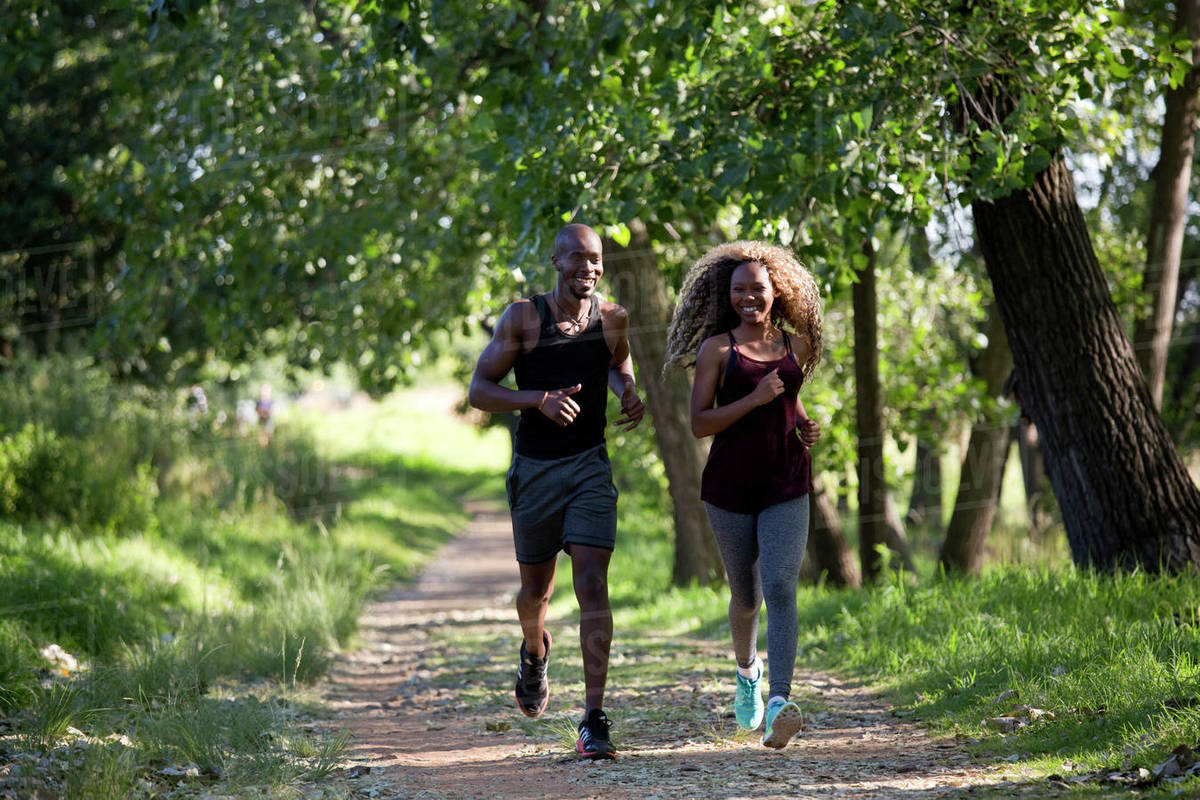 Man and woman jogging in a park - Stock Photo - Dissolve