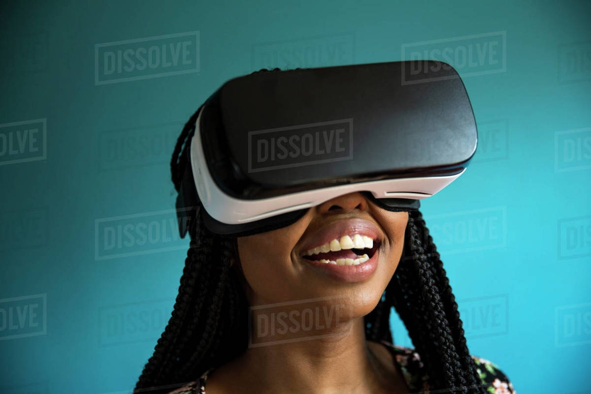 African man looking through VR headset - Stock Photo - Dissolve