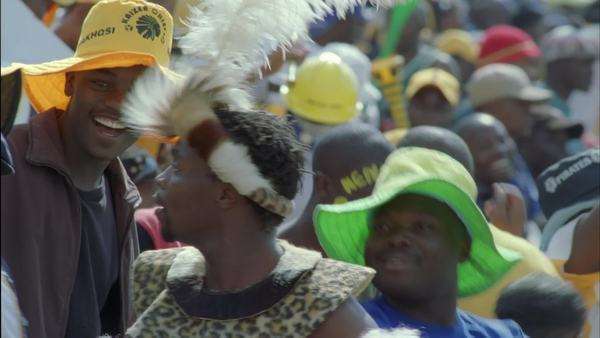 Close up of a man in traditional Zulu garments and other soccer fans in ...