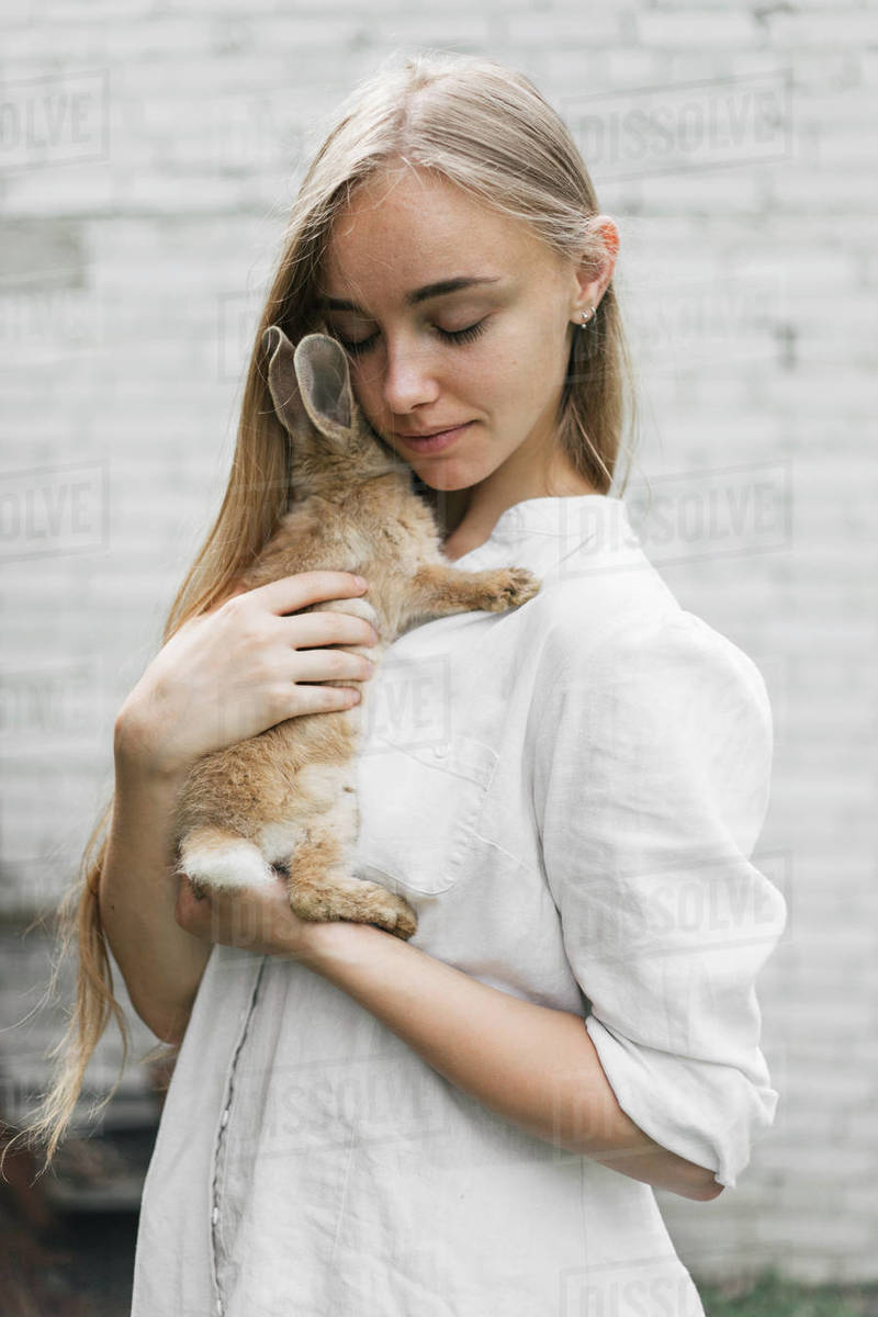 Young woman holds a little cute rabbit in her arms - Royalty-free Stock ...
