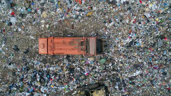 Aerial top down view of truck unloading garbage, waste at landfill ...