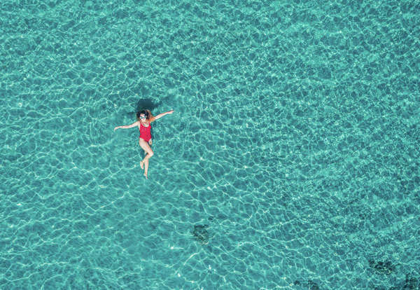 Aerial View of a Woman in Red Swimsuit Floating Serenely on the Crystal ...