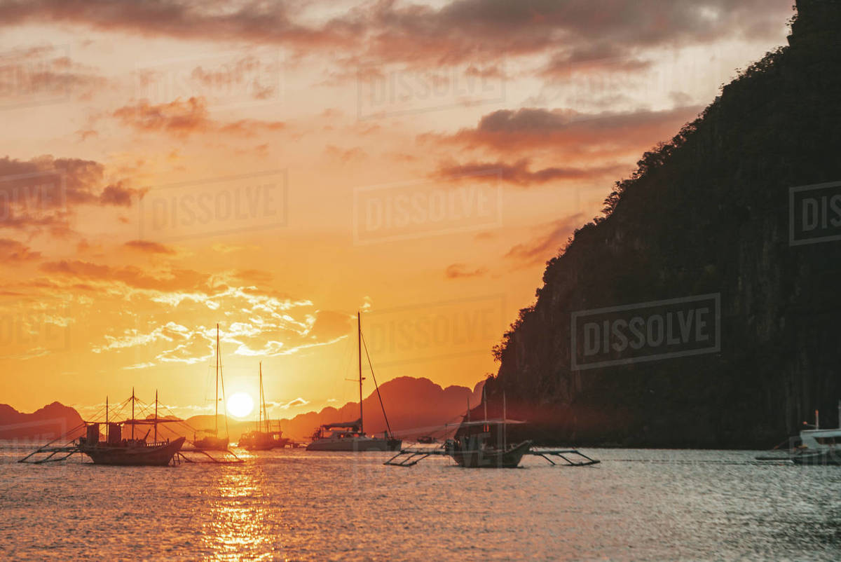 Beautiful sunset with silhouettes of philippine boats in El Nido ...