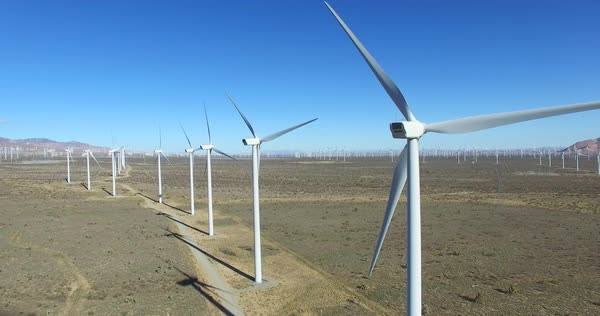 A high angle aerial over a Mojave desert wind farm as it generates ...