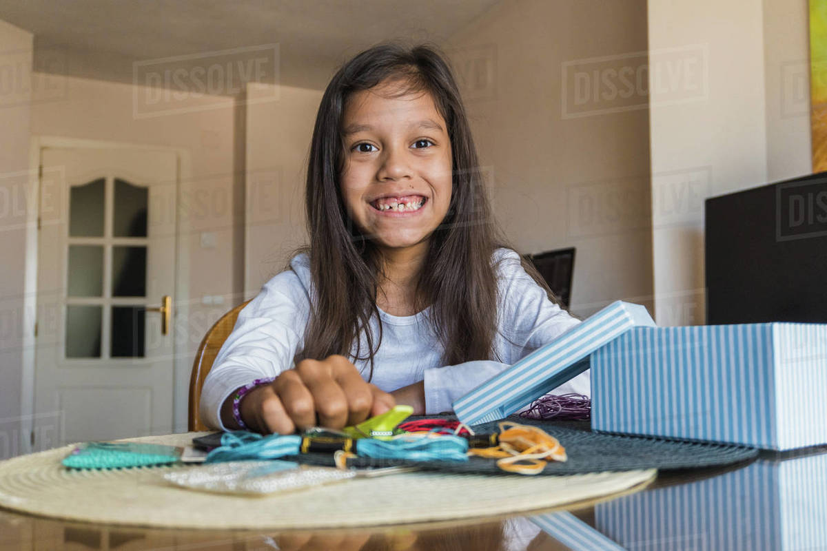 Portrait of hispanic cute girl looking to the camera, making thread ...