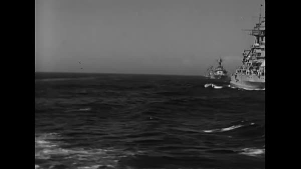 A fleet of United States Navy warships is shown at sea as well as a ...