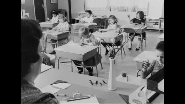 Students put their belongings away in their desks and fold their hands ...