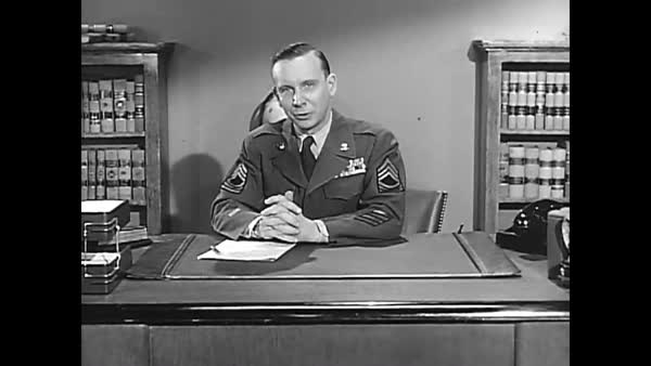 A United States Army sergeant sits at his desk and speaks in 1954 ...