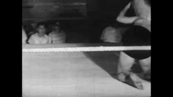 1950s - A woman uses her leg to pin her opponent to the match in a ...
