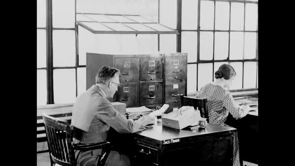 1930s—A woman gets a file for her boss in an office, and a woman works ...