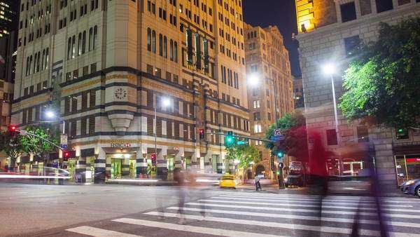 Night timelapse. View on the intersection, trees, skyscapers, moving ...