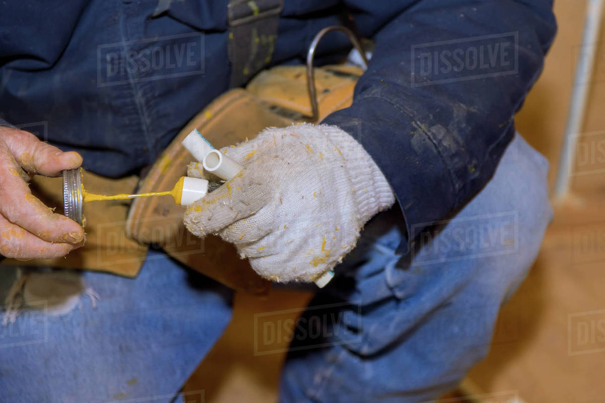 Man gluing parts cement glue off a piece of polypropylene pipes for ...