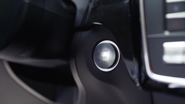 Driver hand pushes engine start stop button. Stock. Modern luxury ...