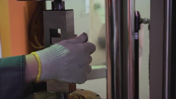 Metal sample is tested for compressive strength. Footage. Close-up of ...