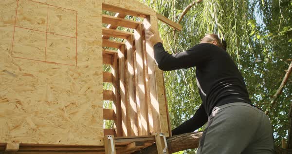 Happy father and son building a tree house in the garden - 4K Royalty ...