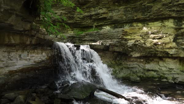 Stationary view of waterfall pouring through canyon in forest - Stock ...