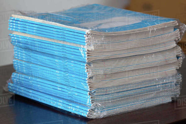 Stack of Notebooks. A pack of blue school notebooks in cellophane on ...