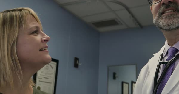 Low angle of a male doctor giving bad news to a female patient and ...