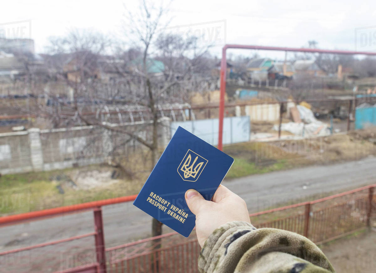 Concept. A Ukrainian soldier in camouflage is holding a Ukrainian ...