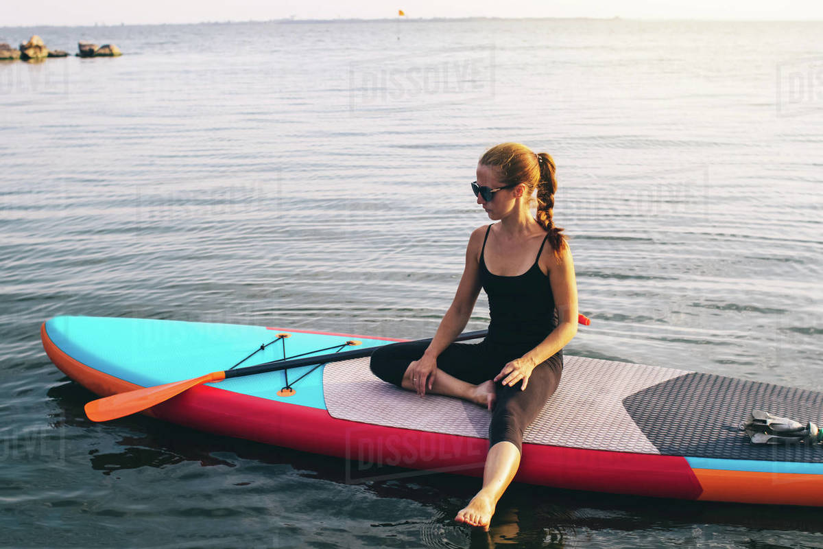 Close-up of a girl floating on a sup board. The concept of water sports ...