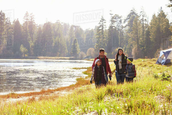 Family on camping trip walk near lake, looking at each other - Royalty ...