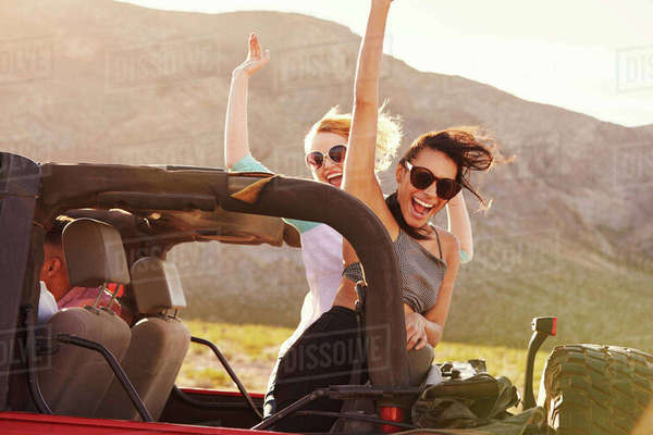 Friends on road trip driving in convertible car - Stock Photo - Dissolve