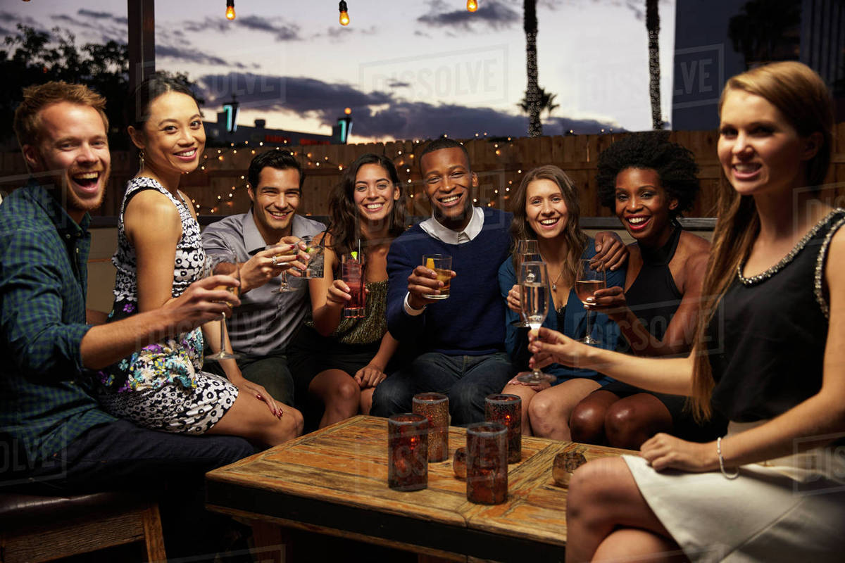 Portrait of friends enjoying night out at rooftop bar - Royalty-free ...