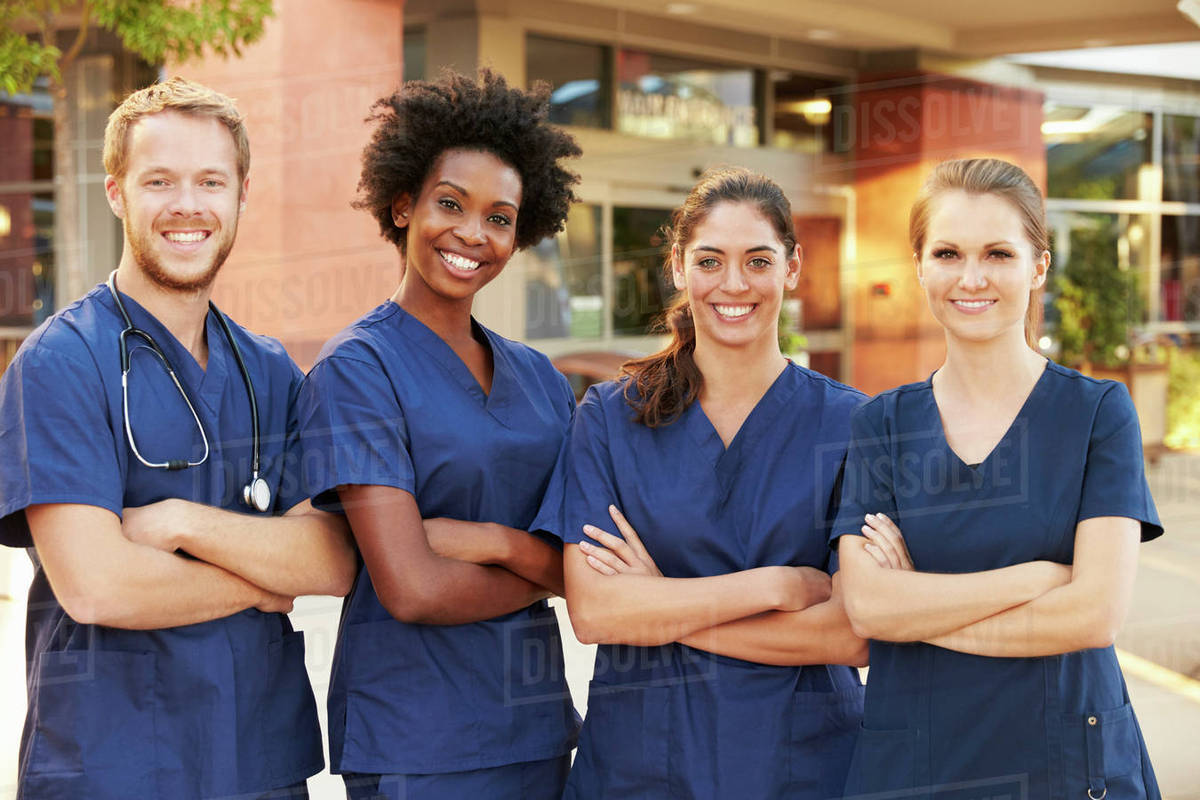 Portrait of medical team standing outside hospital - Stock Photo - Dissolve